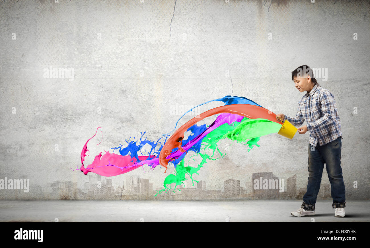 Young boy splashing colorful paint from bucket Stock Photo - Alamy