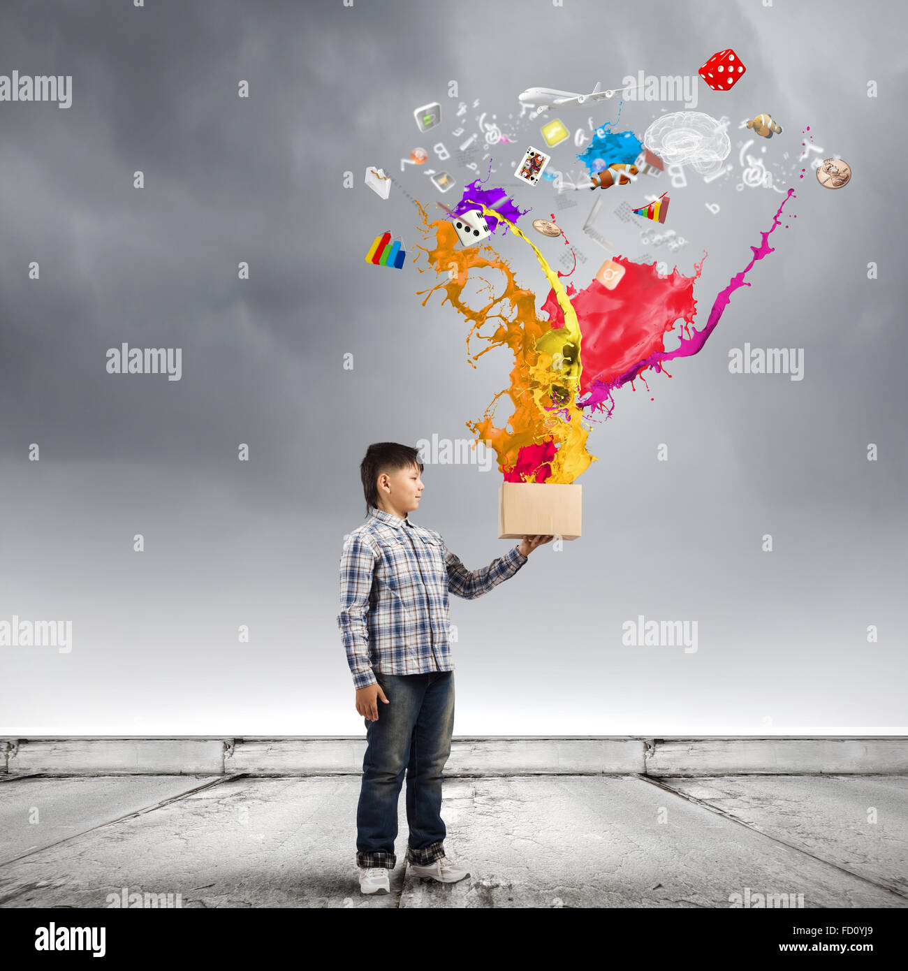 Young boy splashing colorful paint from bucket Stock Photo - Alamy