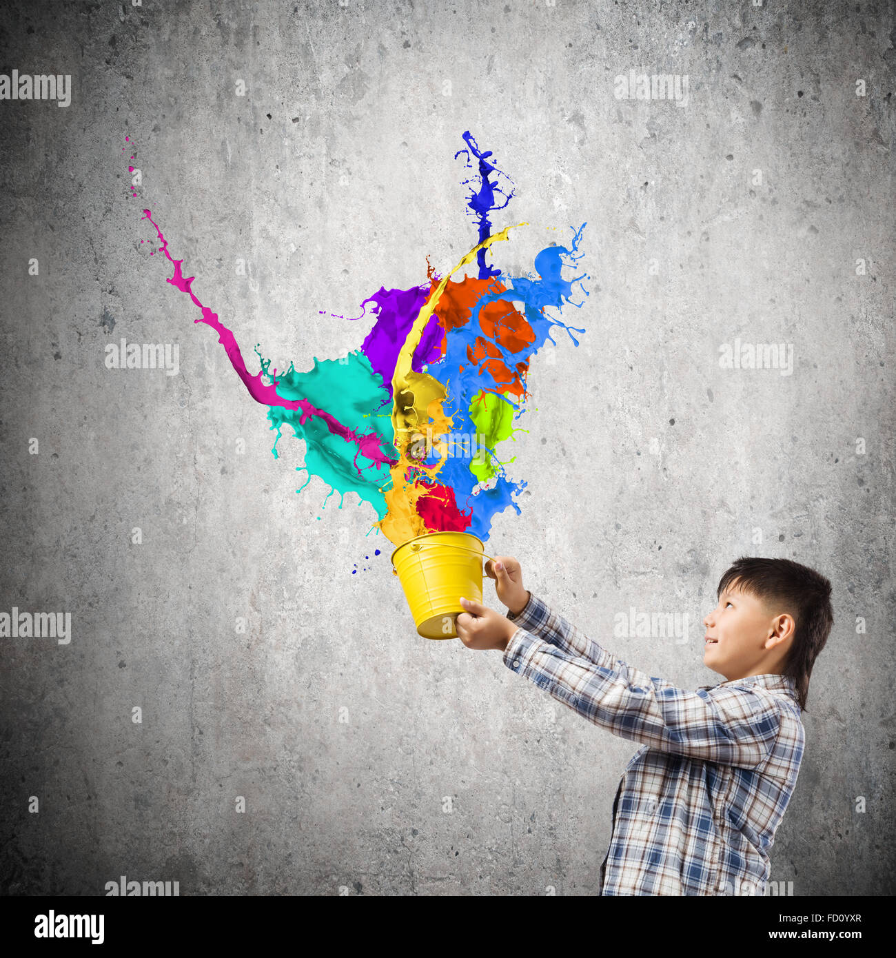 Young boy splashing colorful paint from bucket Stock Photo - Alamy