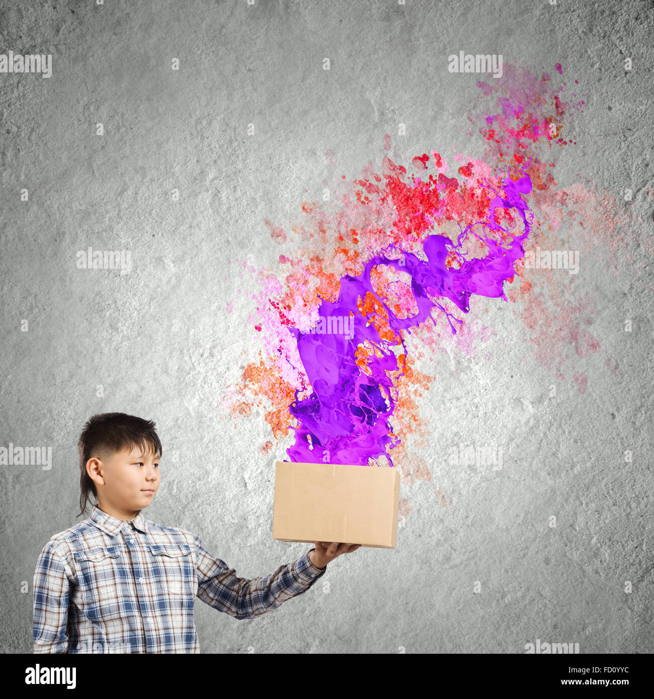 Young boy splashing colorful paint from carton box Stock Photo - Alamy