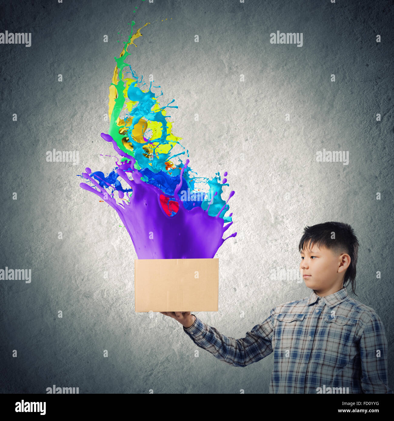 Young boy splashing colorful paint from carton box Stock Photo - Alamy