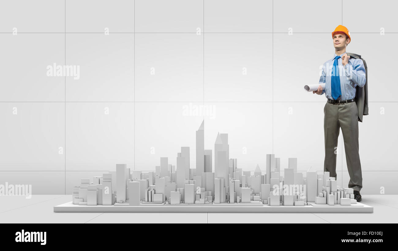 Young businessman examining model of construction project Stock Photo ...