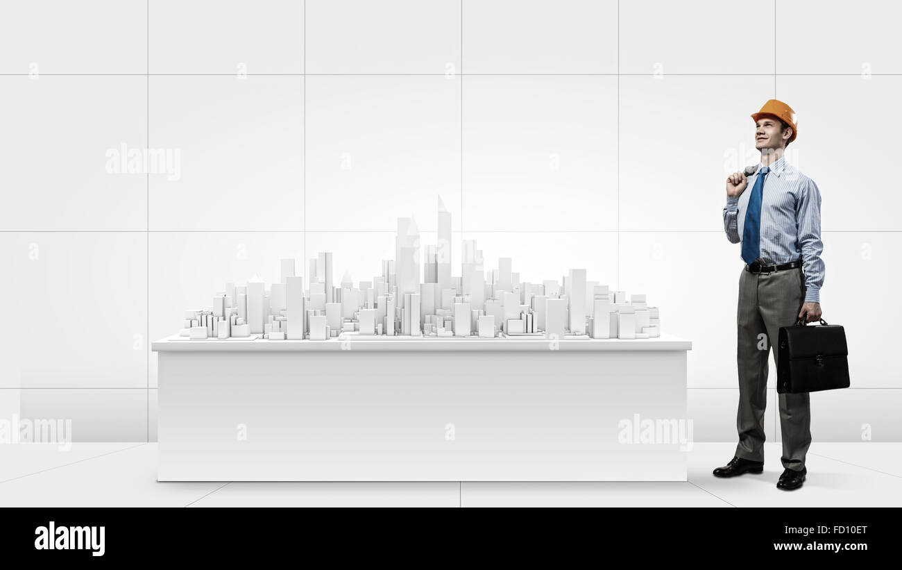 Young businessman examining model of construction project Stock Photo ...
