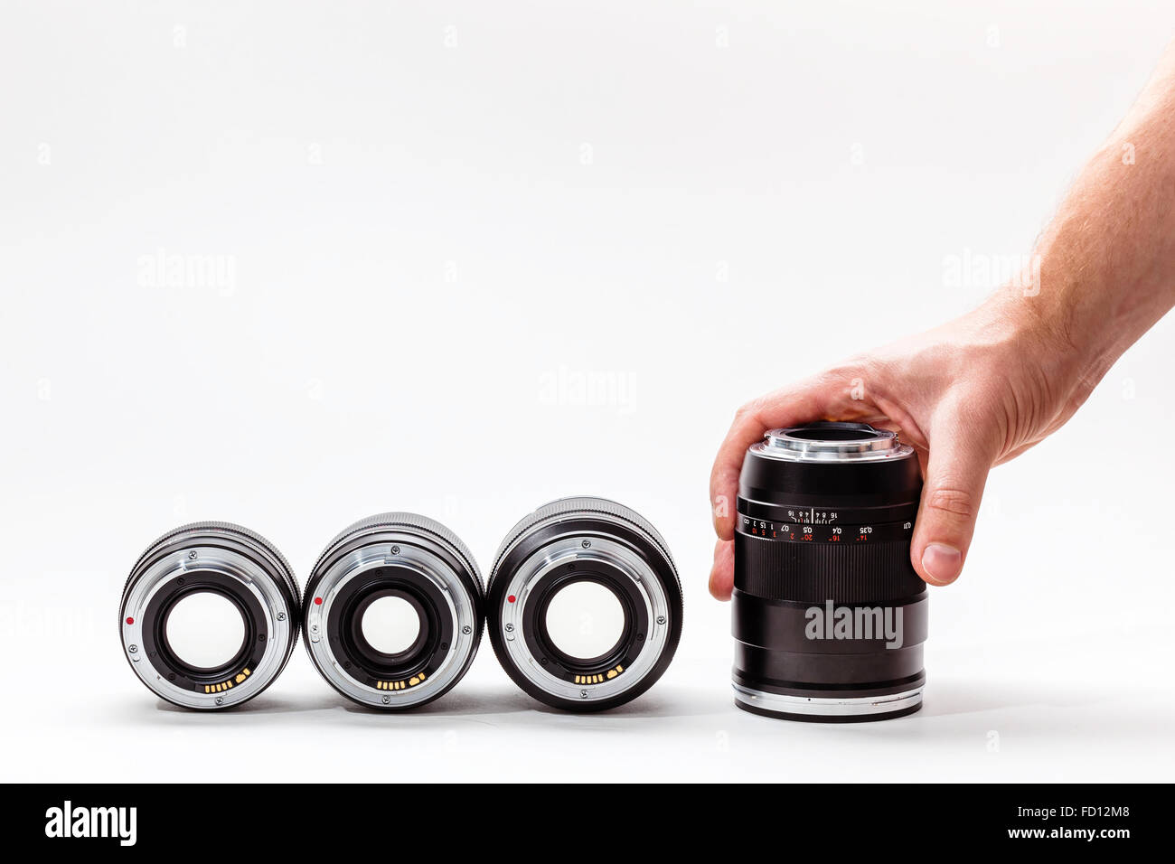 Man's hand adjusts a photographic lens. A collection of expensive toys ...