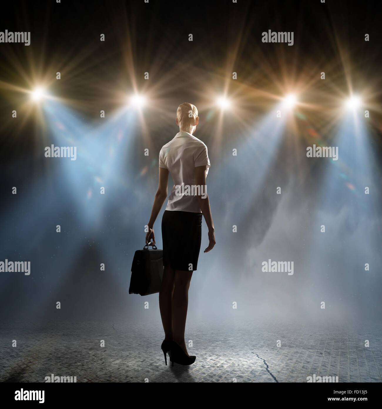 Rear view of businesswoman standing in lights of stage Stock Photo - Alamy