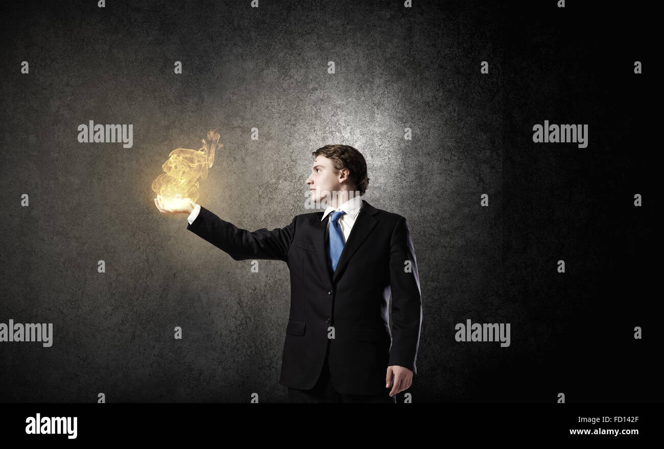 Young businessman holding fire flames in palm Stock Photo - Alamy