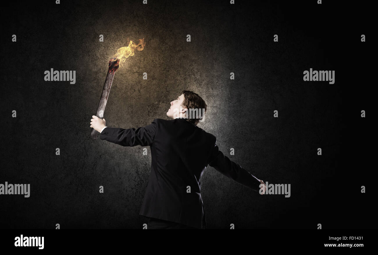 Young businessman holding burning torch in hand Stock Photo - Alamy