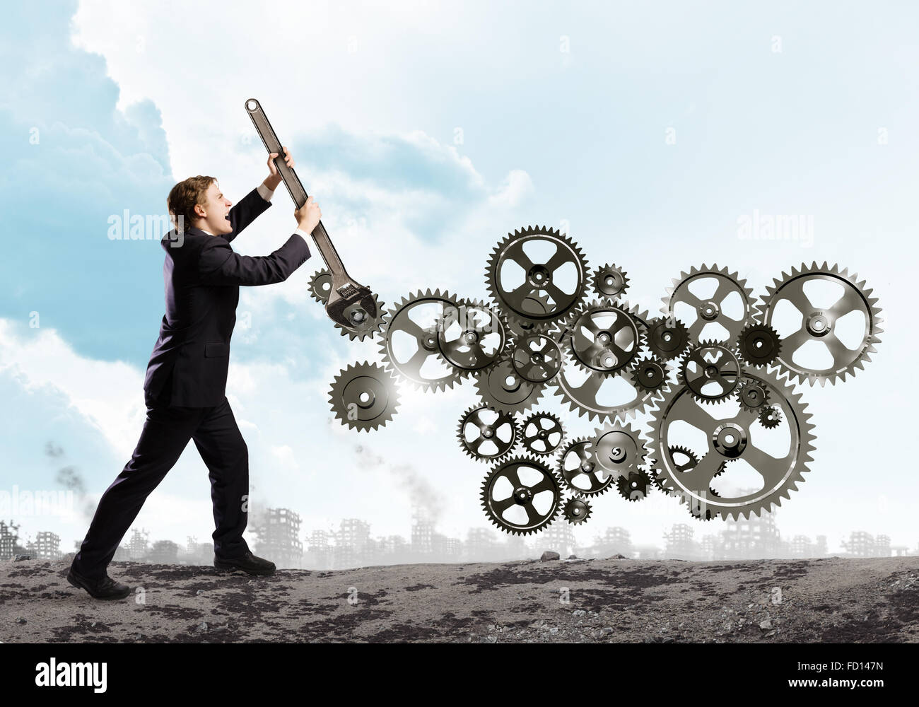 Young businessman fixing gears mechanism with wrench Stock Photo - Alamy