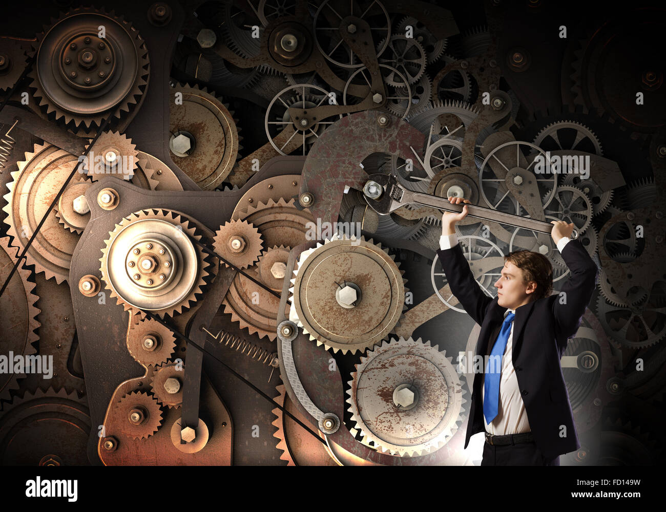 Young businessman fixing gears mechanism with wrench Stock Photo - Alamy