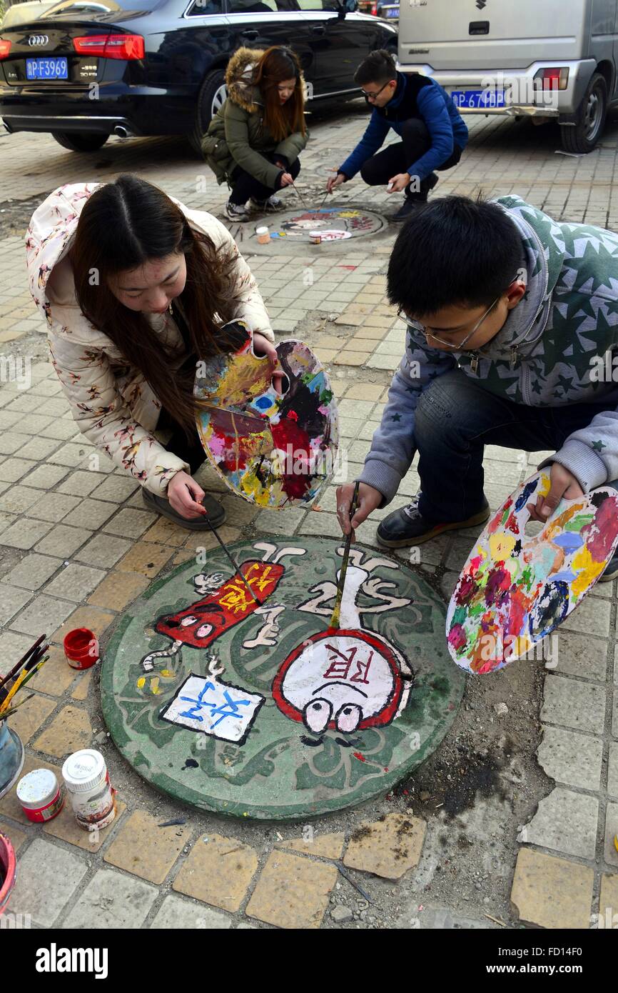 Chn. 26th Jan, 2016. Students paint on the manhole covers. © SIPA Asia ...
