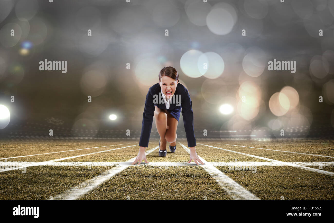 Young attractive businesswoman at stadium standing in start position ...