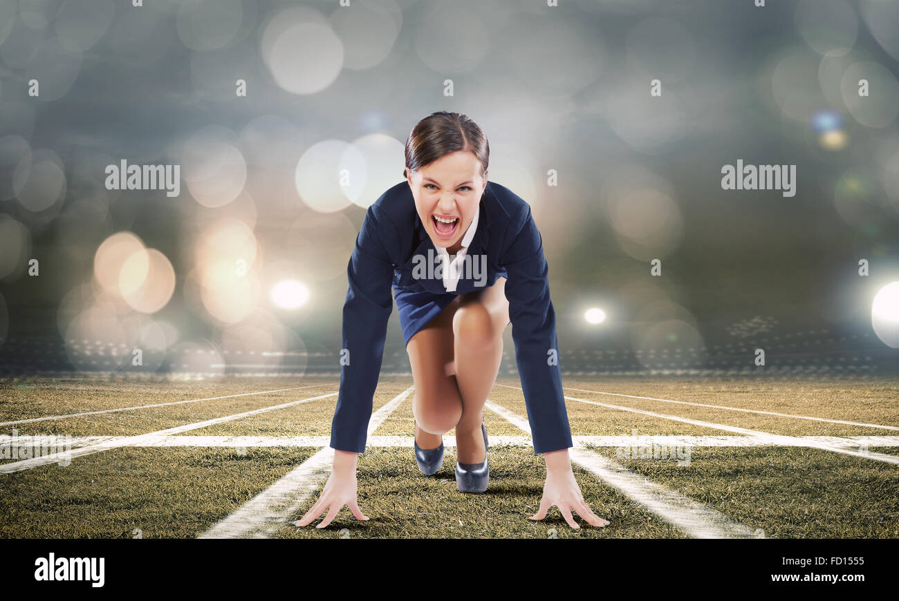 Young attractive businesswoman at stadium standing in start position ...