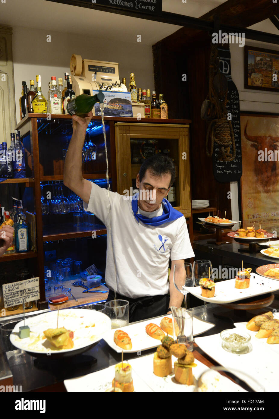 A Basque barman pouring traditional white wine called Txakoli in a ...