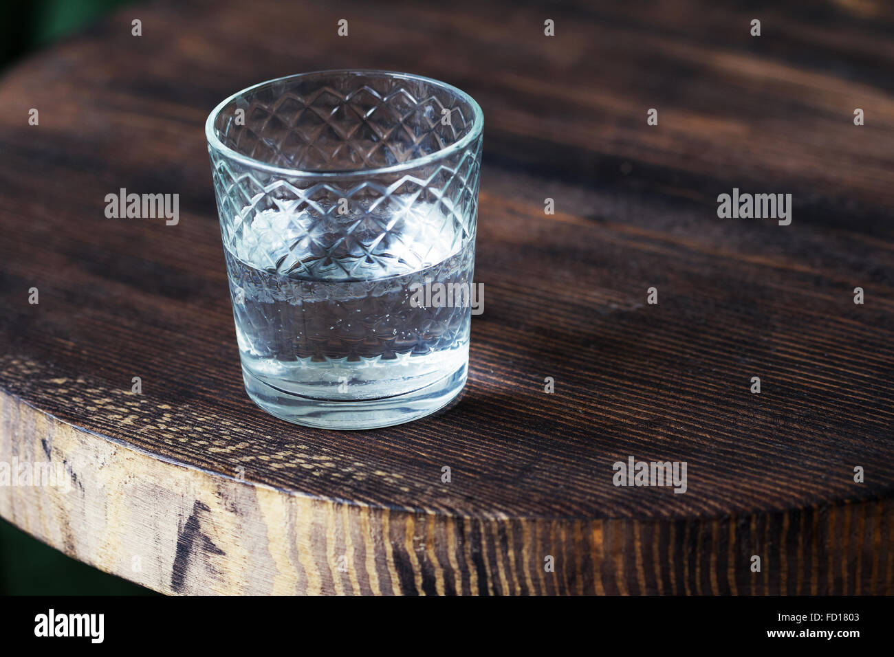 An authentic glass of drinking water on the old wooden table. Full-time ...