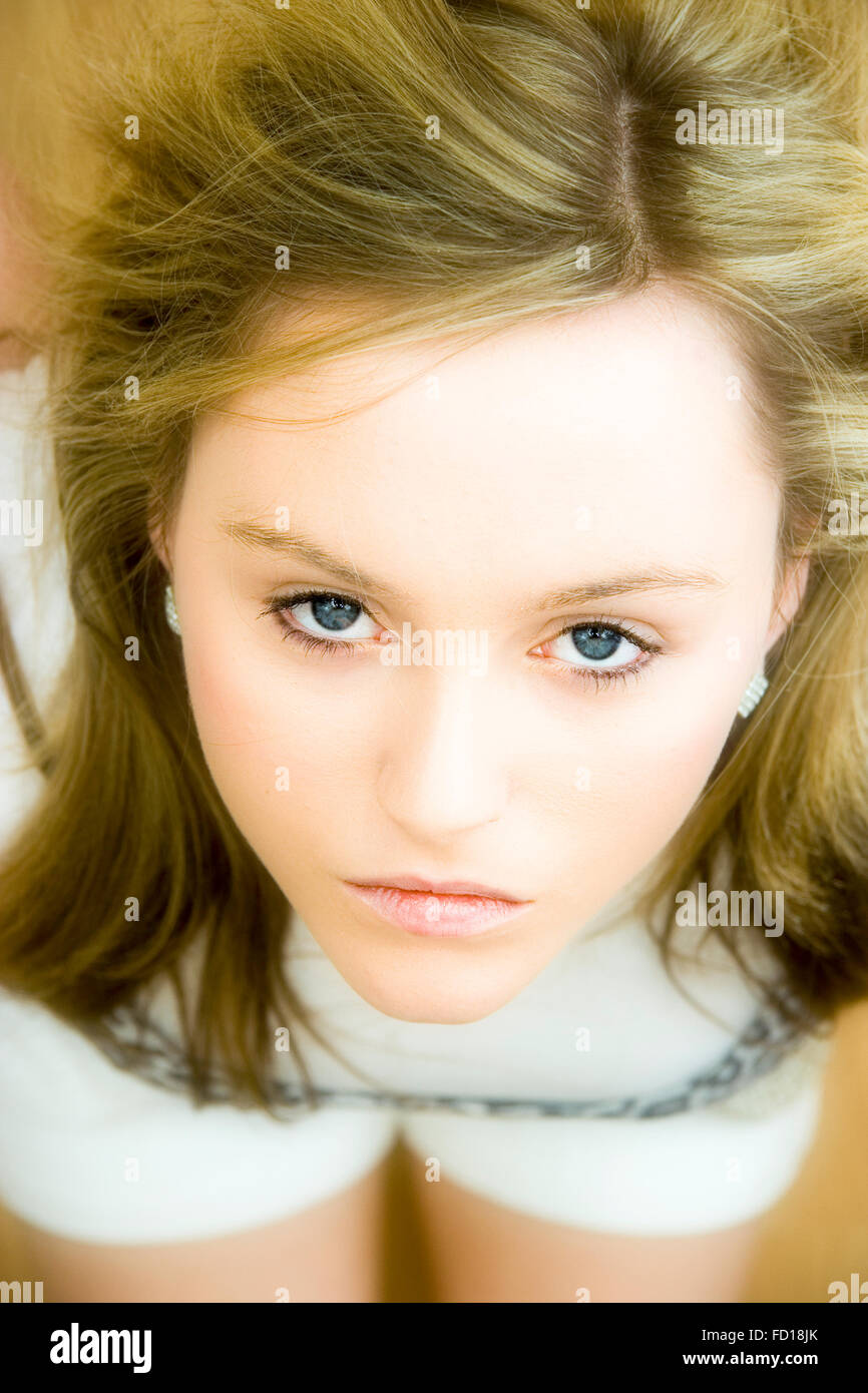 Caucasian teenage girl. Sitting on floor, head back and looking up at ...