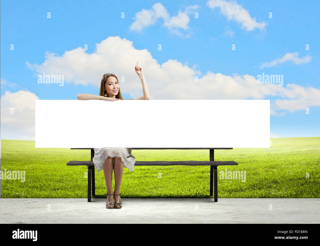 Young asian woman sitting on bench with blank banner Stock Photo - Alamy