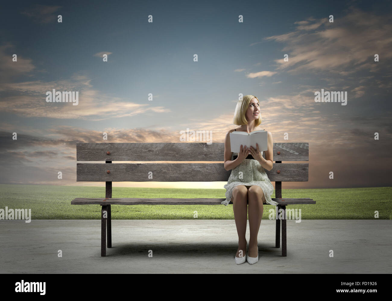 Young pretty woman sitting on bench and reading book Stock Photo - Alamy