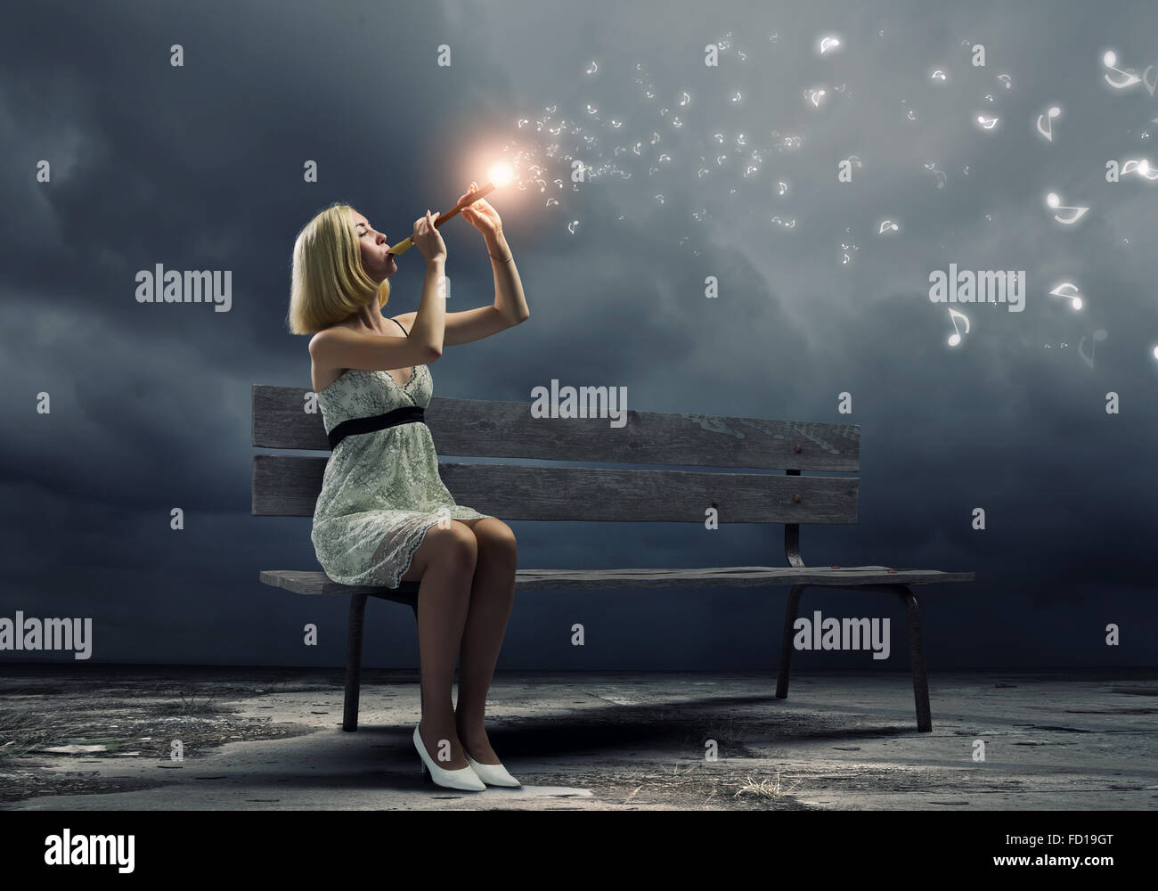 Young woman sitting on bench and playing fife Stock Photo - Alamy