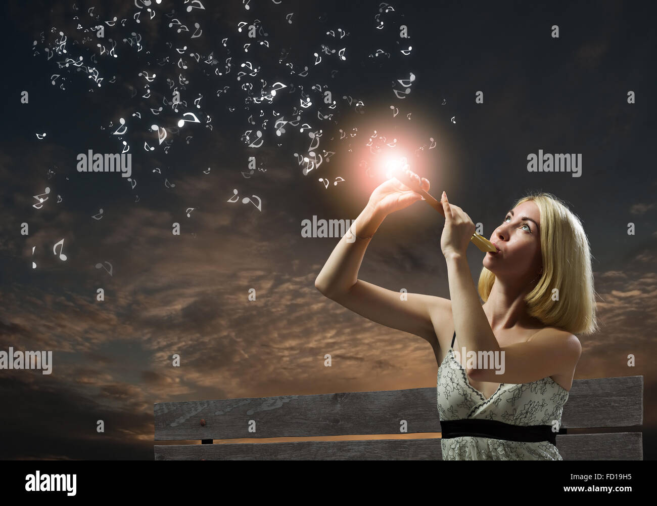 Young woman sitting on bench and playing fife Stock Photo - Alamy