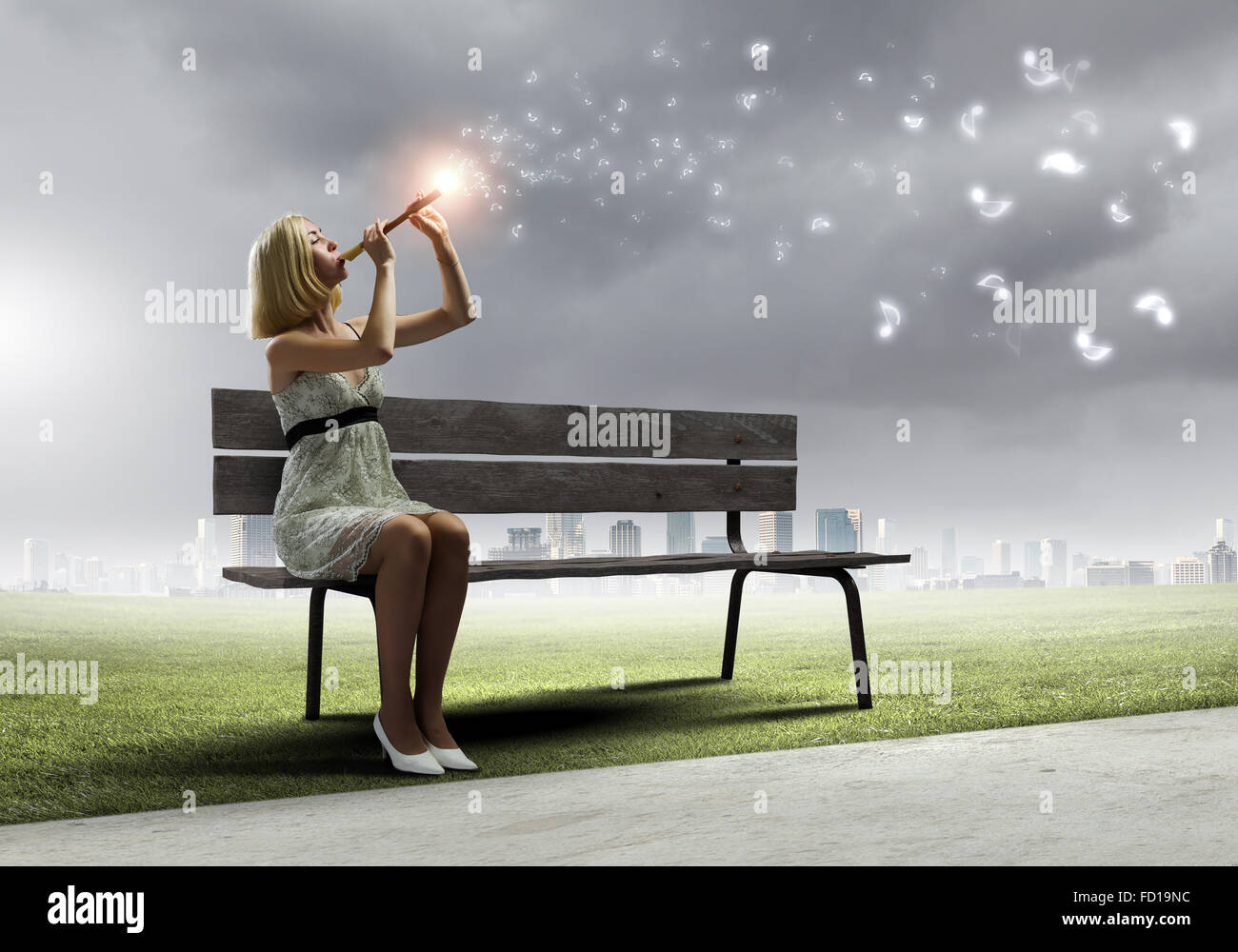 Young woman sitting on bench and playing fife Stock Photo - Alamy
