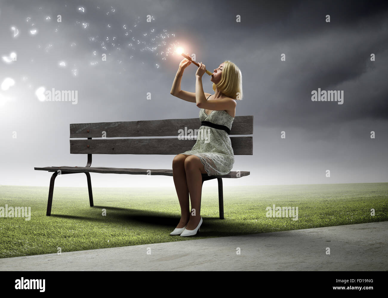 Young woman sitting on bench and playing fife Stock Photo - Alamy
