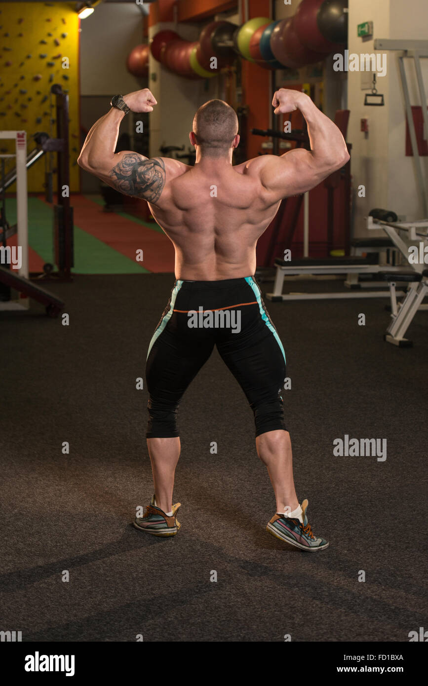 Serious Man Standing Strong In The Gym And Flexing Muscles Stock Photo ...
