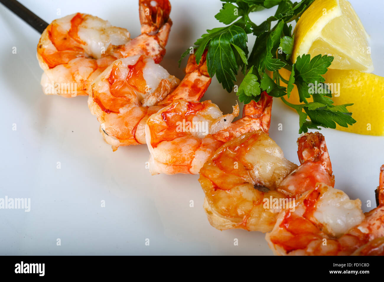 Tiger prawn skewer served sliced lemon and parsley Stock Photo - Alamy