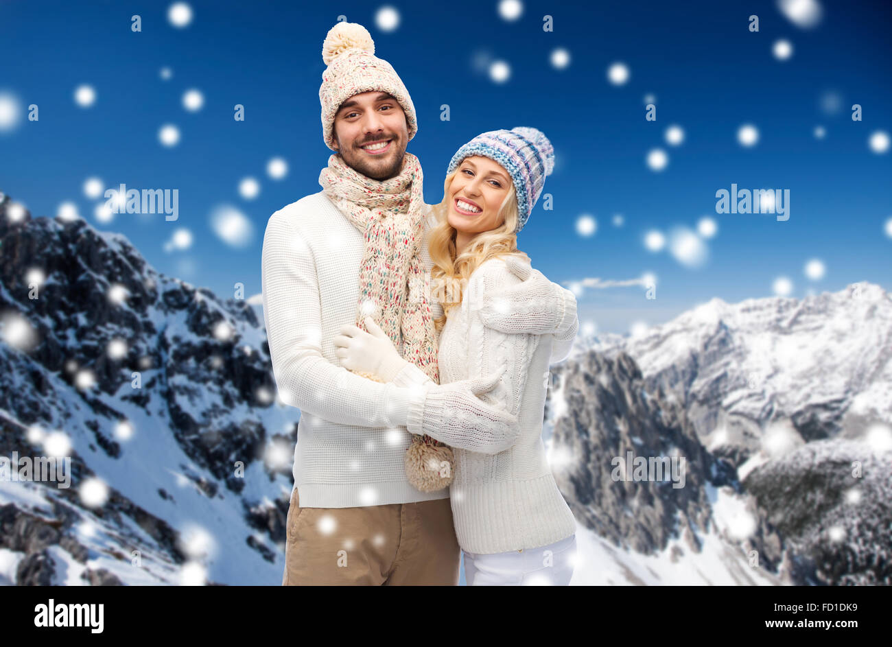 couple in winter clothes over snowy mountains Stock Photo - Alamy