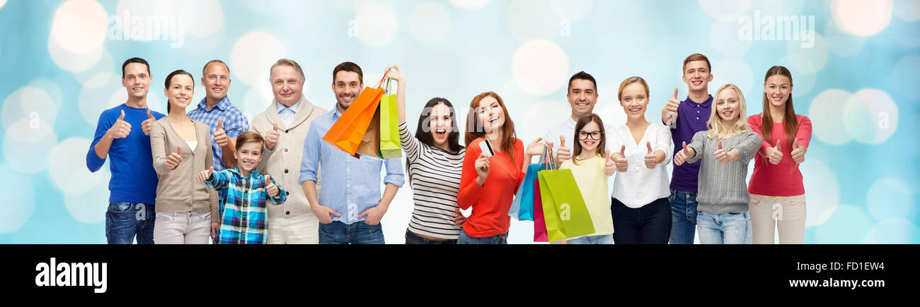 happy people with shopping bags showing thumbs up Stock Photo - Alamy