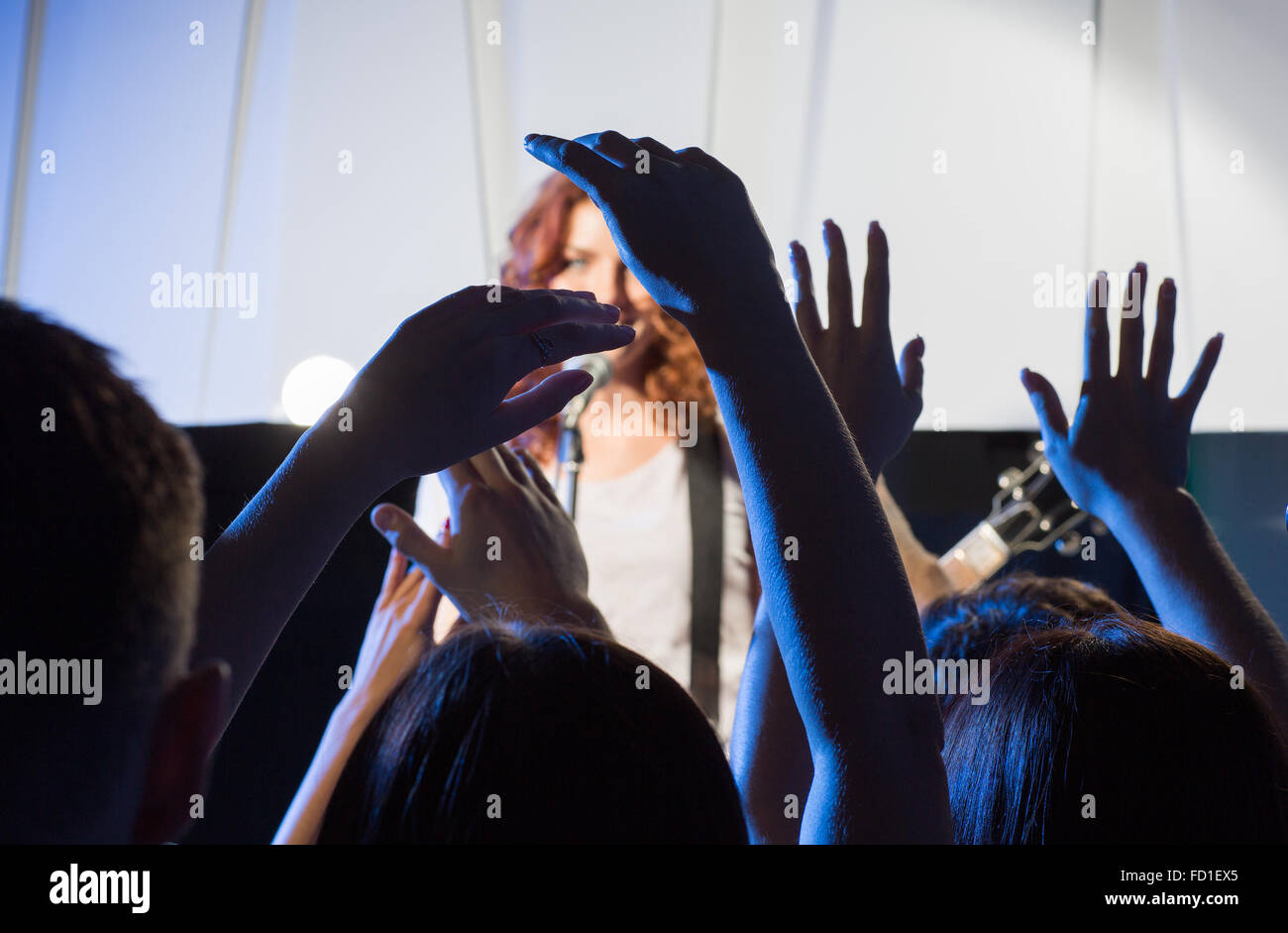 female singer with guitar over happy fans hands Stock Photo - Alamy