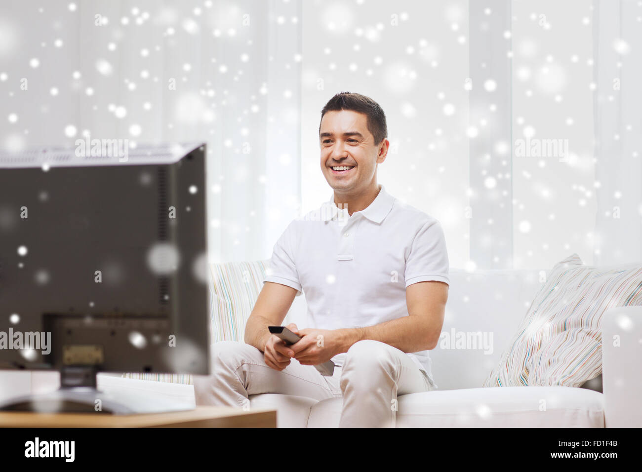 smiling man with remote control watching tv Stock Photo - Alamy