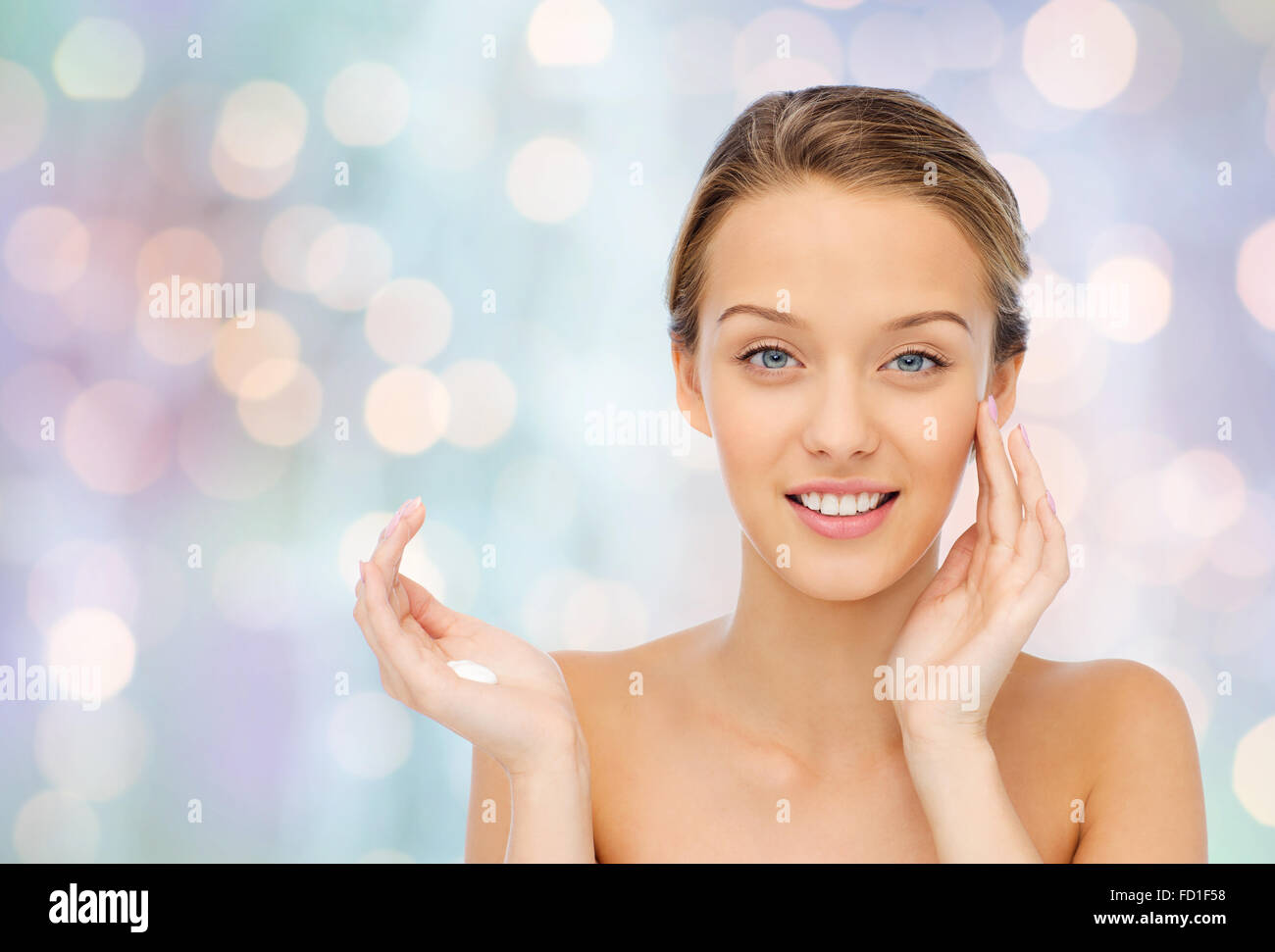 happy young woman applying cream to her face Stock Photo - Alamy
