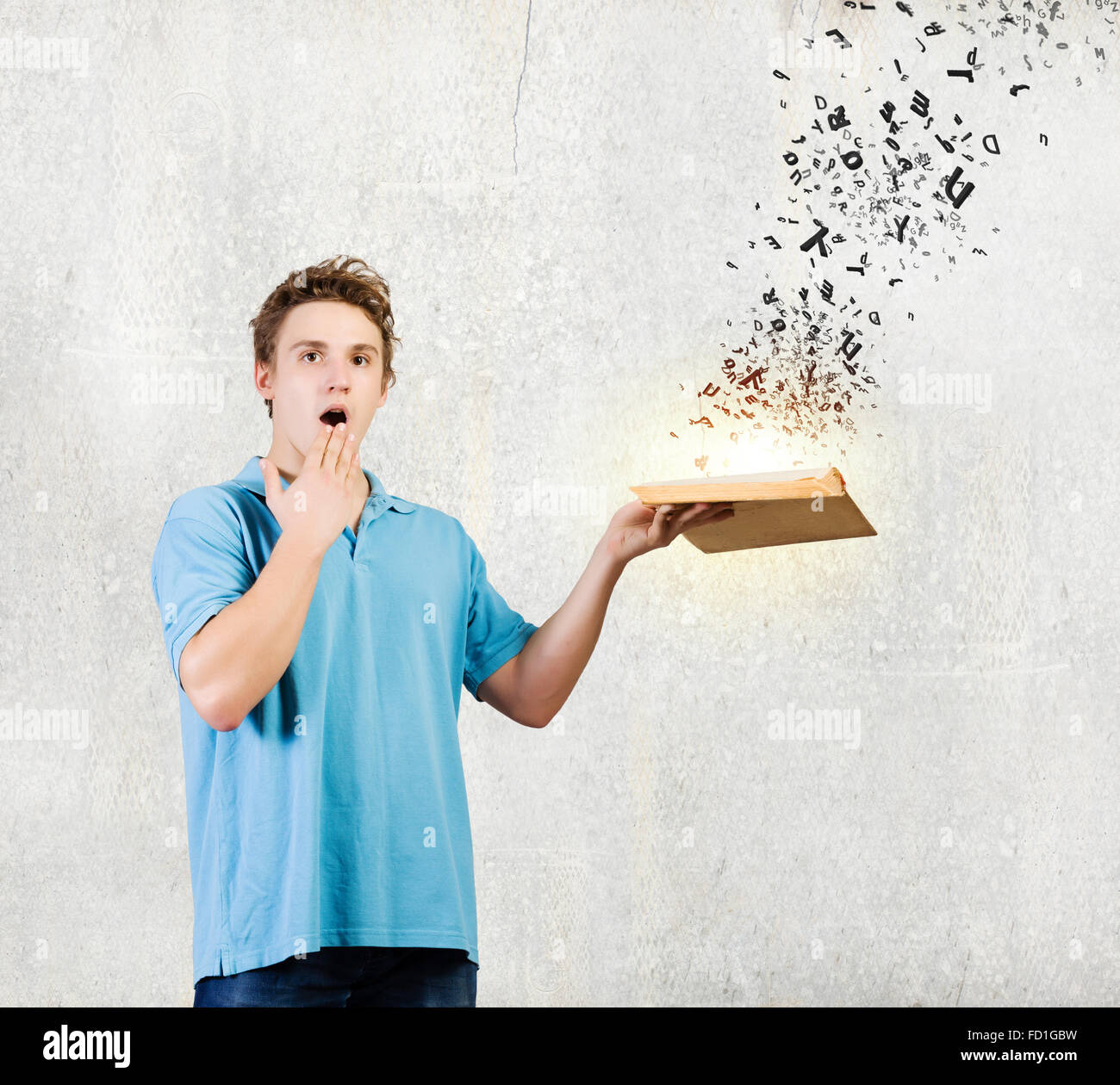 Young man with opened book and characters flying out Stock Photo - Alamy