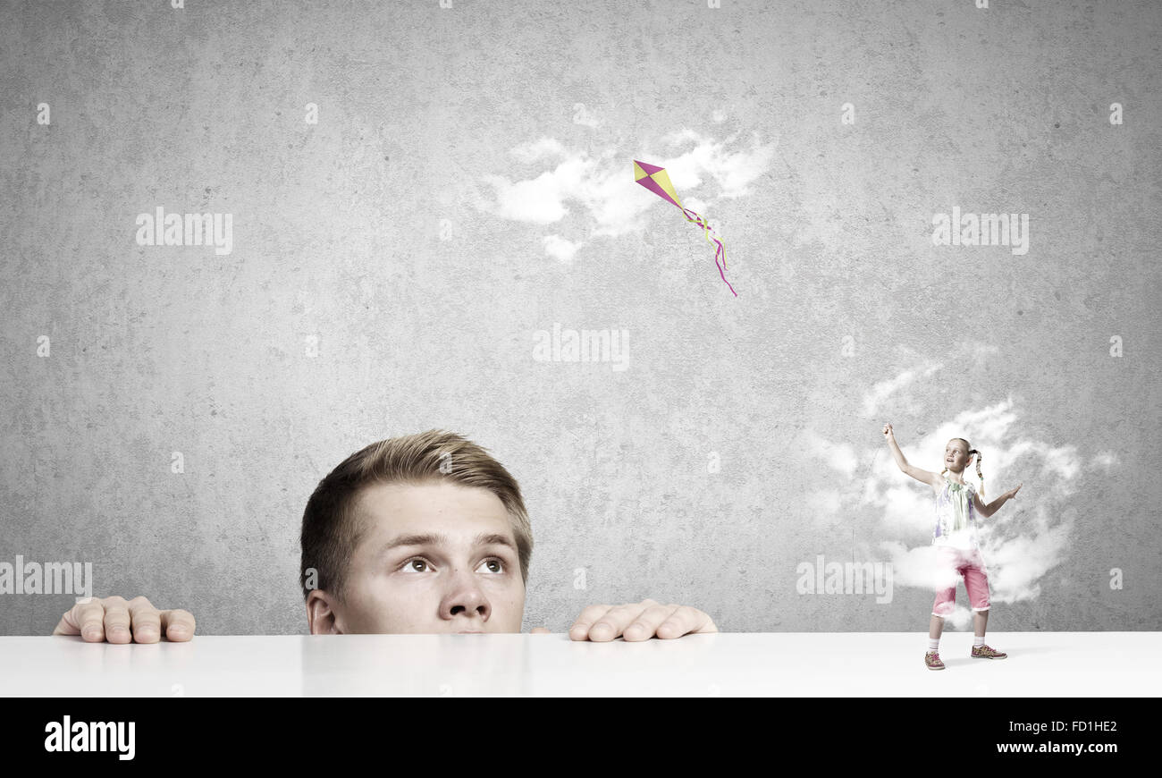 Young man looking out from under the table Stock Photo - Alamy