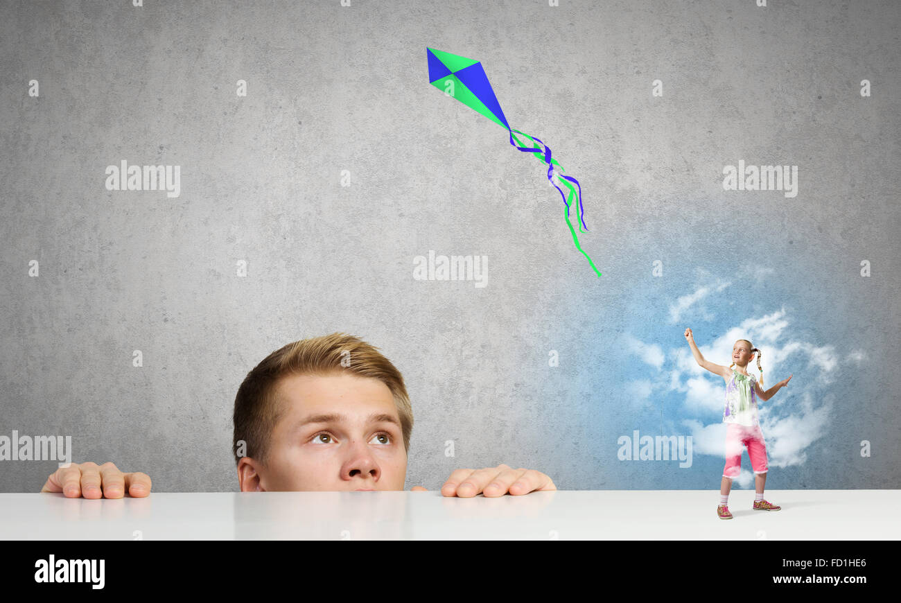 Young man looking out from under the table Stock Photo - Alamy