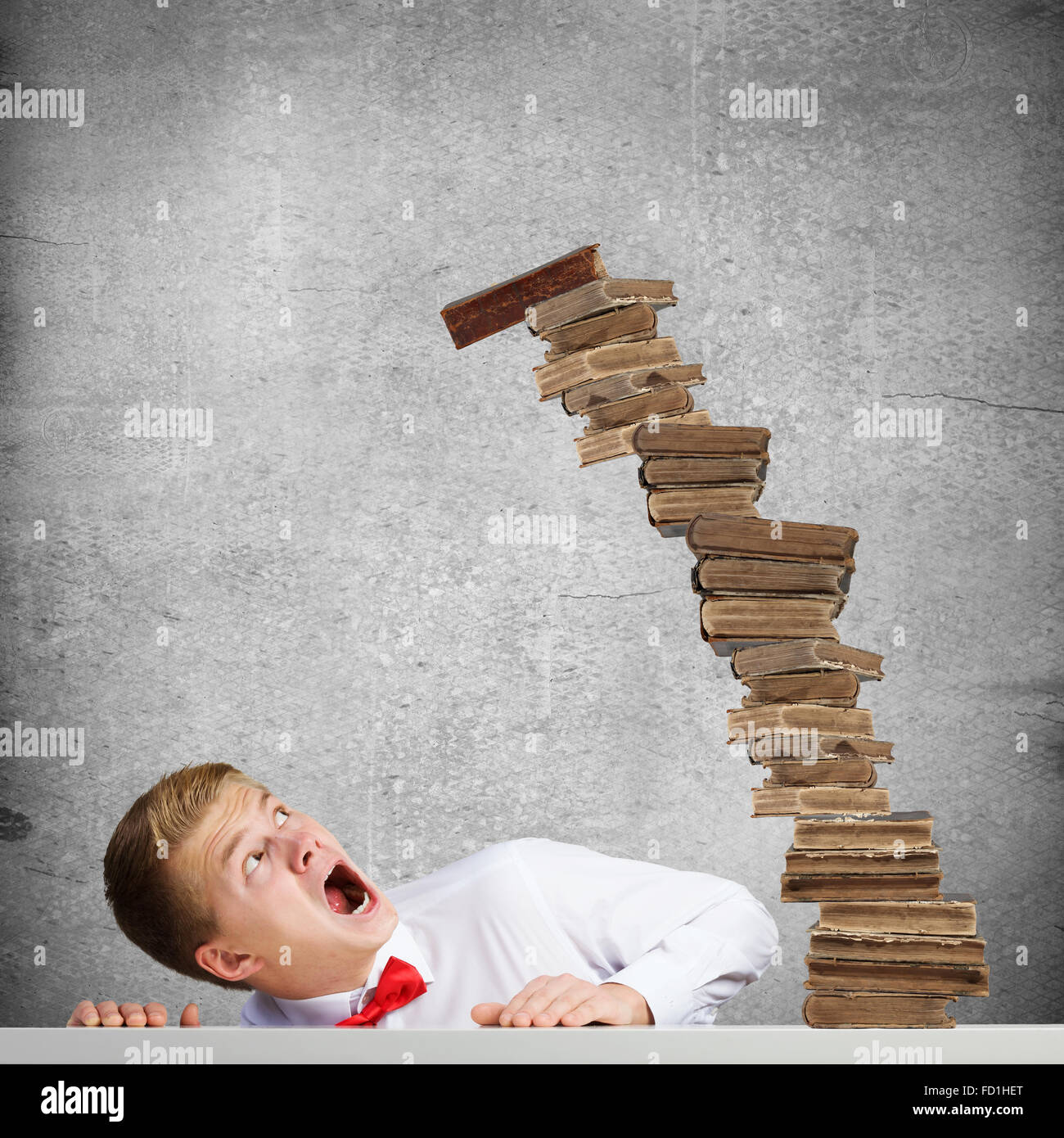Young handsome businessman and falling pile of books hi-res stock ...