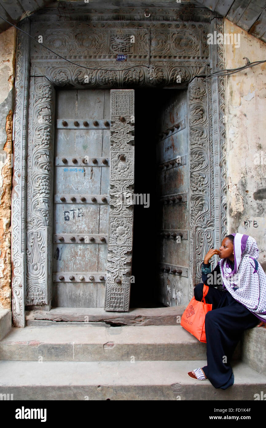 Traditional house with old door and woman in traditional Muslim clothes ...