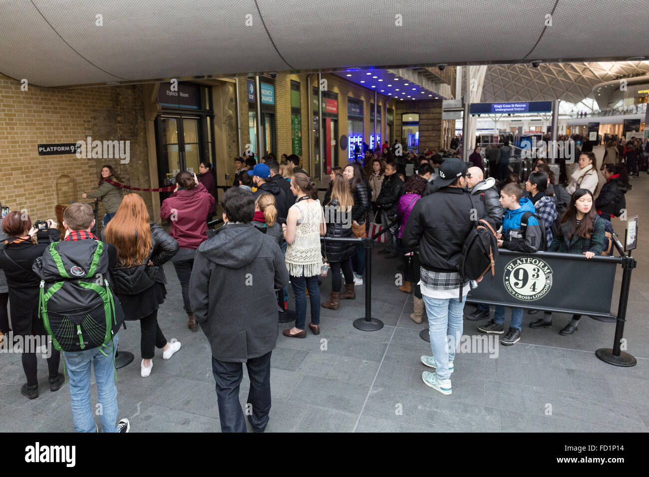 A queue of people waiting at platform 9 3/4 at Kings Cross station ...