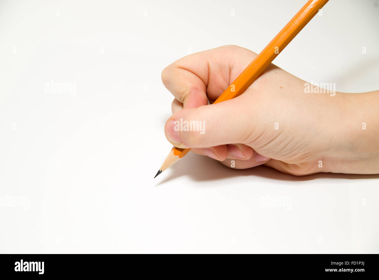Kid's hand holding a pencil on a white Stock Photo - Alamy
