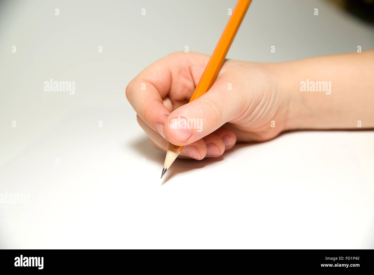 Kid's right hand holding a pencil on a white Stock Photo - Alamy