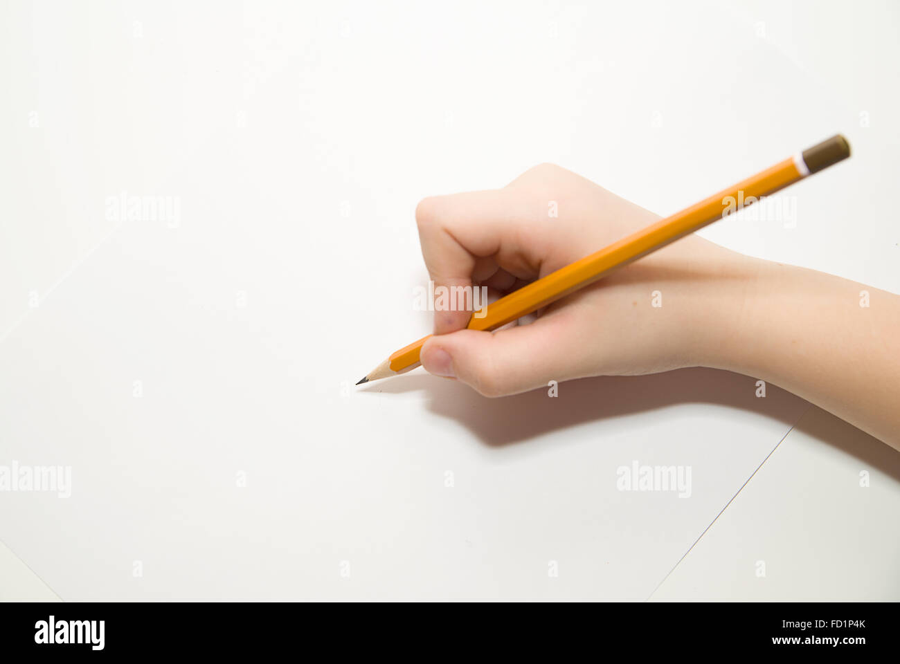 Kid's right hand holding a pencil on a white Stock Photo - Alamy
