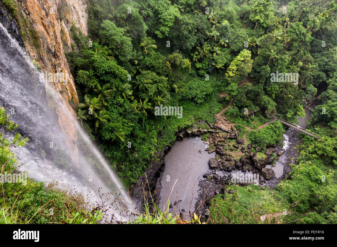 Waterfall looking over cliff drop to lagoon and tropical rain forest in ...