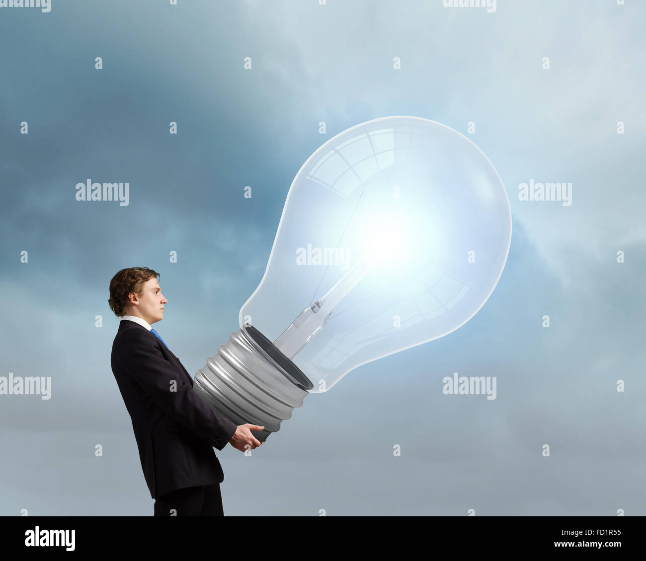 Young businessman carrying in hands big light bulb Stock Photo - Alamy