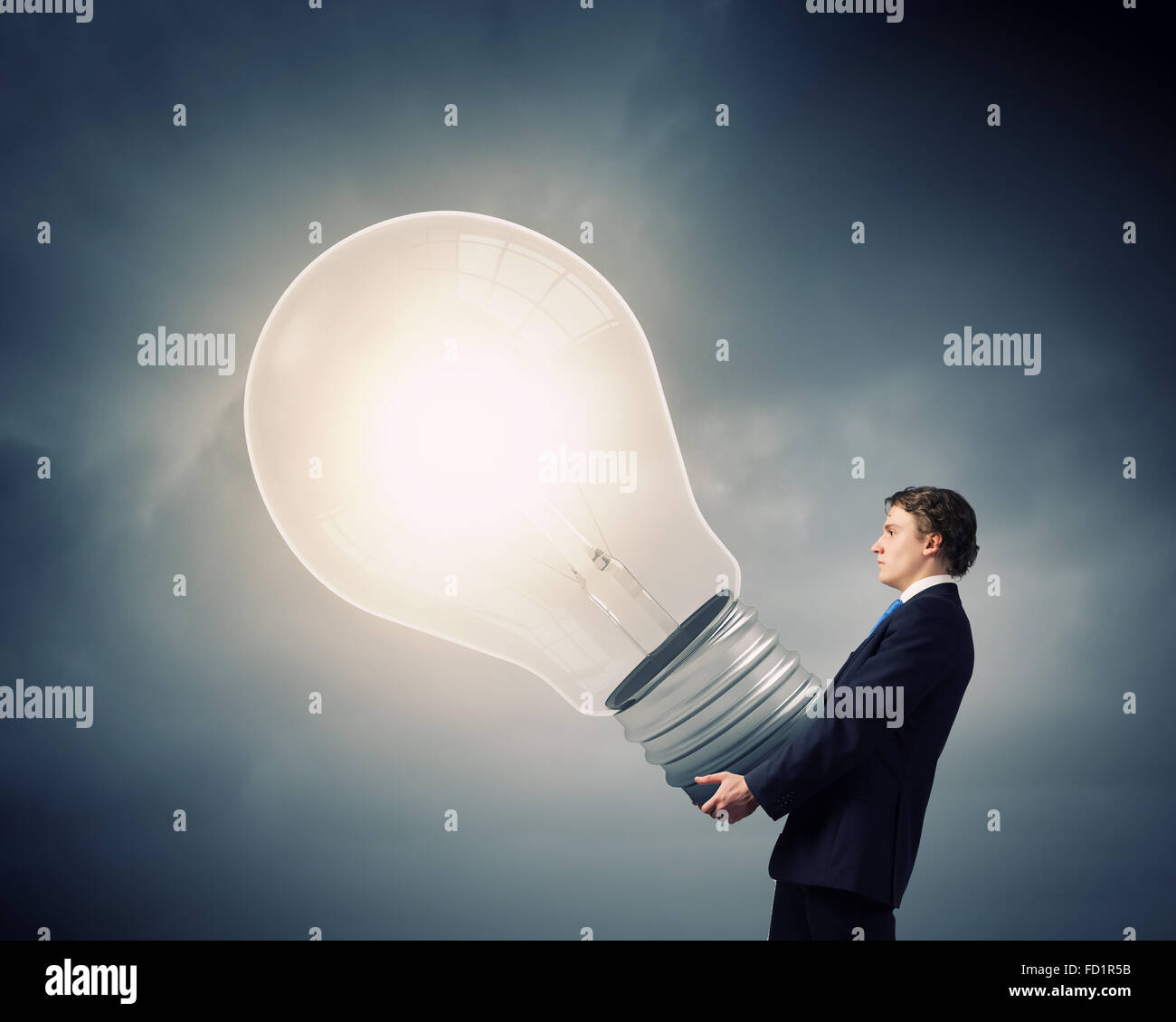 Young businessman carrying in hands big light bulb Stock Photo - Alamy