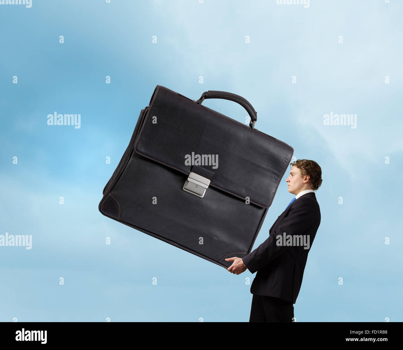 Young determined businessman carrying big heavy suitcase Stock Photo ...