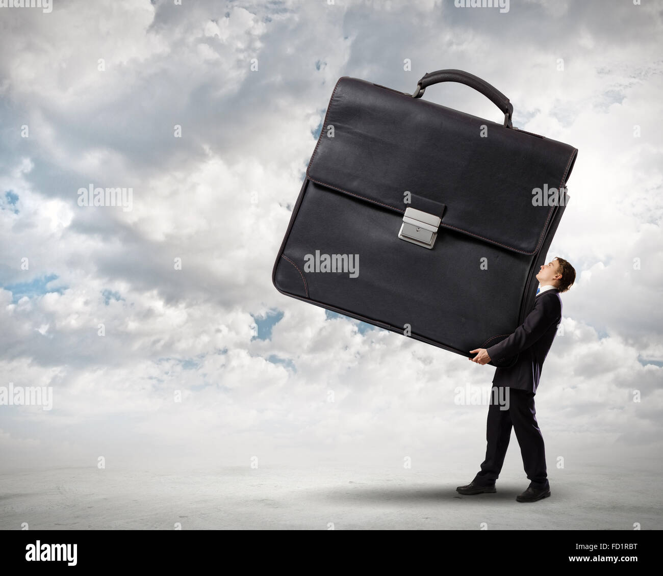 Young determined businessman carrying big heavy suitcase Stock Photo ...
