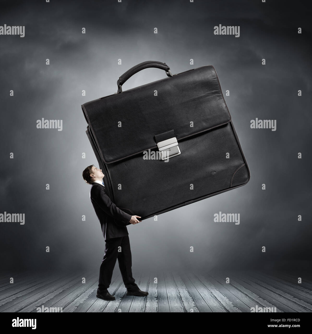 Young determined businessman carrying big heavy suitcase Stock Photo ...