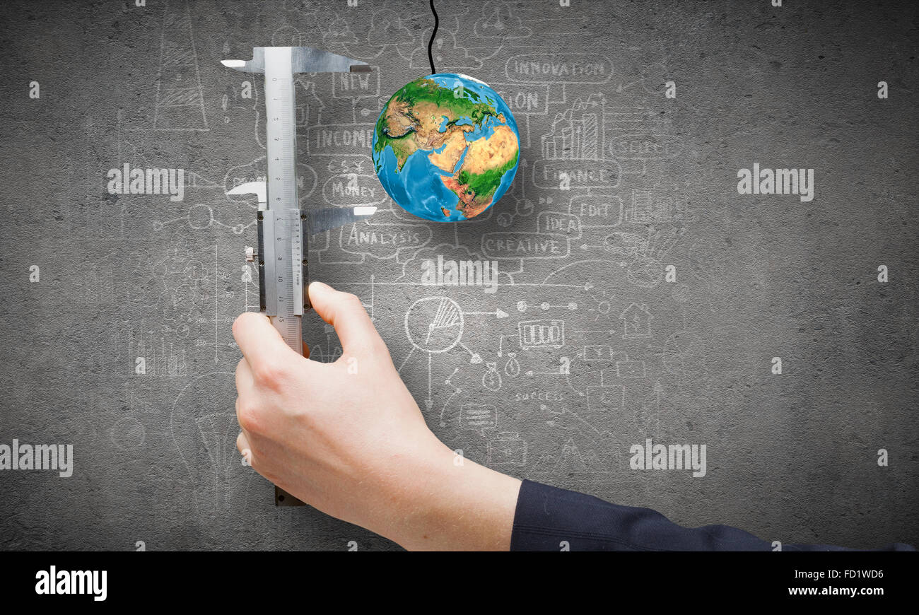 Close up of business person hand measuring Earth planet. Elements of ...
