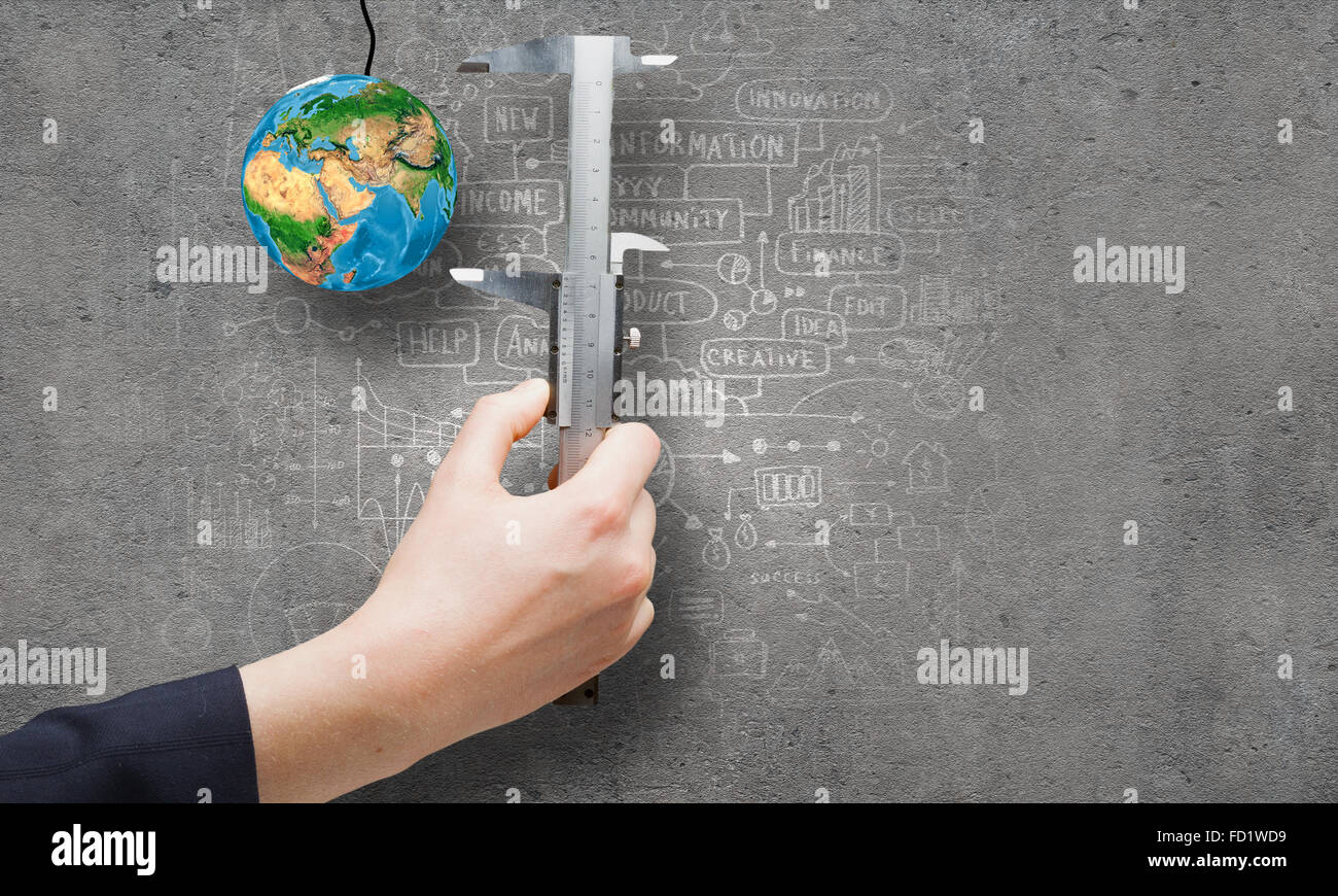 Close up of business person hand measuring Earth planet. Elements of ...