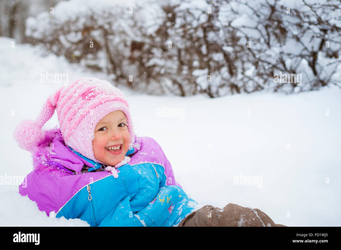 Cheerful little girl playing with snow in Park Stock Photo - Alamy